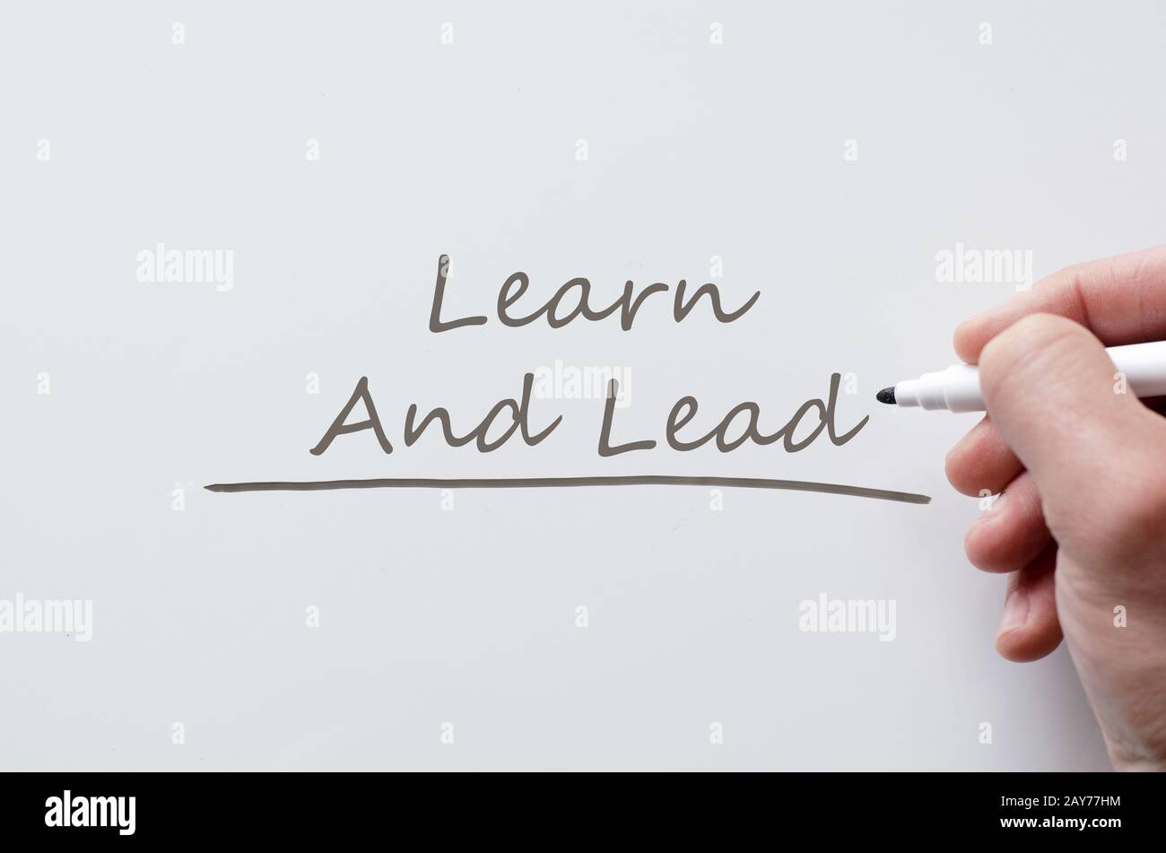 Learn and lead written on whiteboard Stock Photo - Alamy