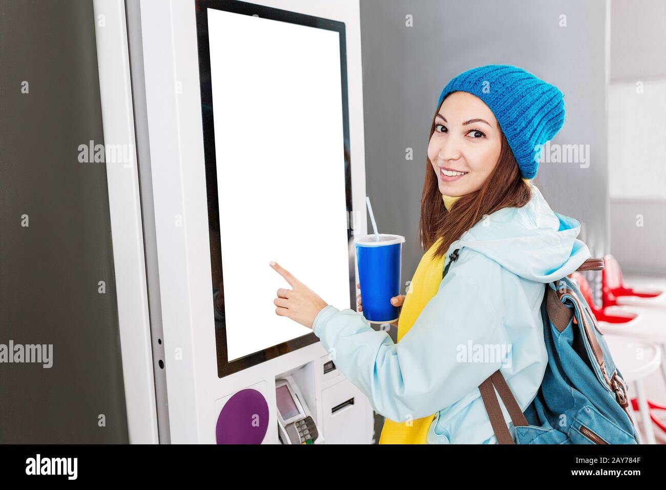A woman orders food in the touch screen terminal with electronic menu ...