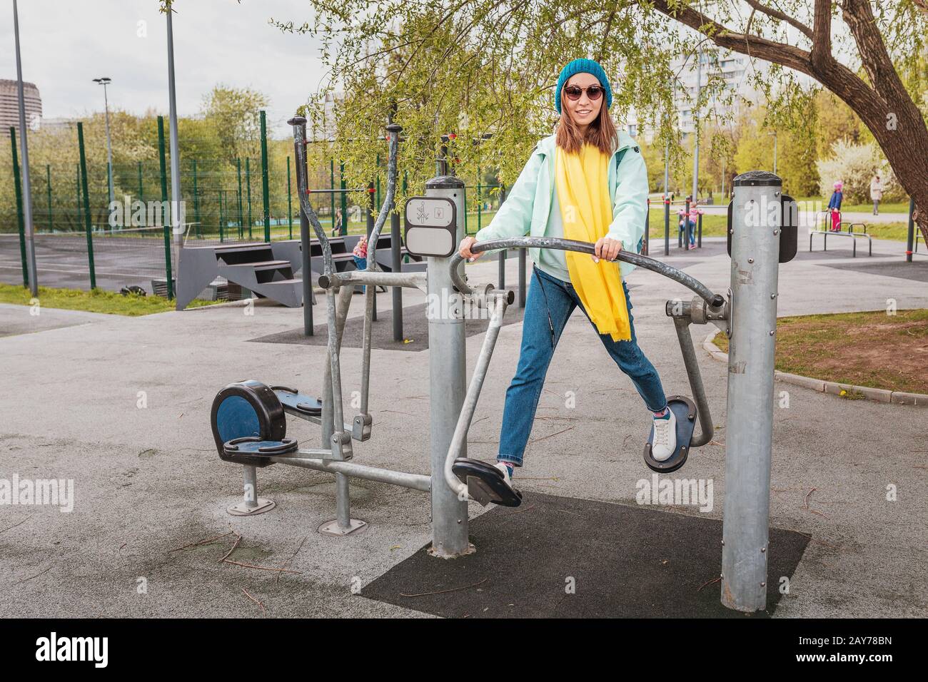 Woman have fun and exercising at outdoors gym playground equipment ...