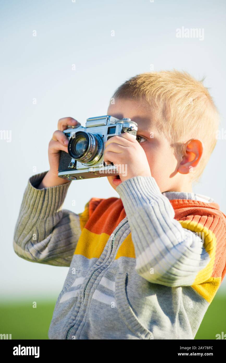 Little boy with an old camera shooting outdoor Stock Photo - Alamy