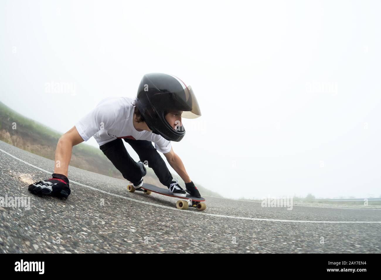 A young guy in a full face helmet in a slide passes a turn Stock Photo ...