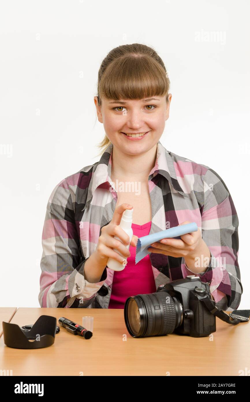 Girl photographer performs cleaning of the camera body from external ...