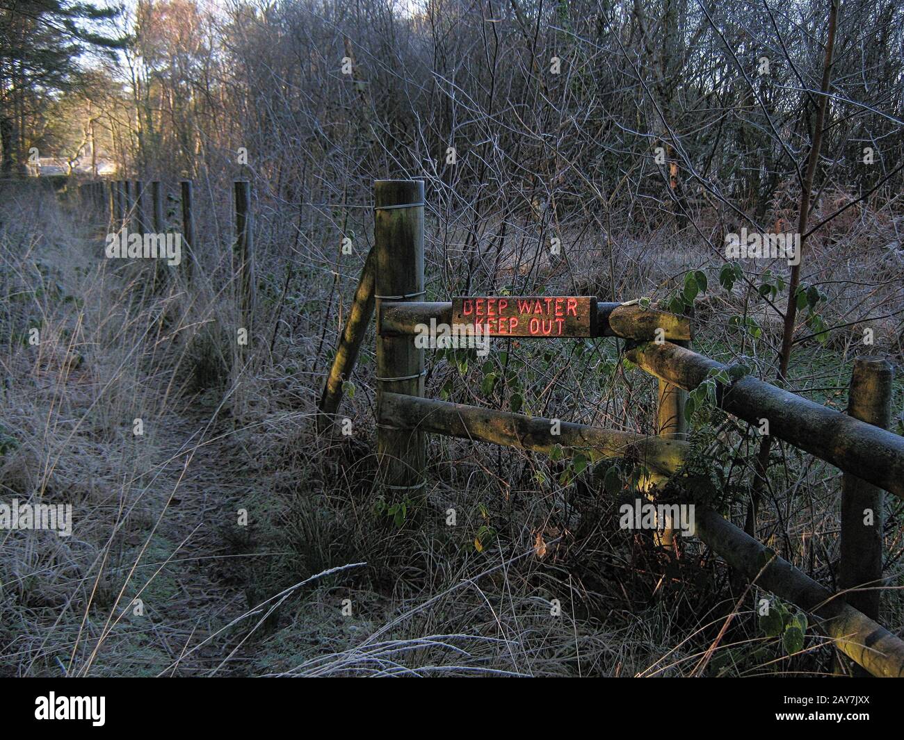 Deep water keep out sign fixed to wooden fence with posts and wire on ...