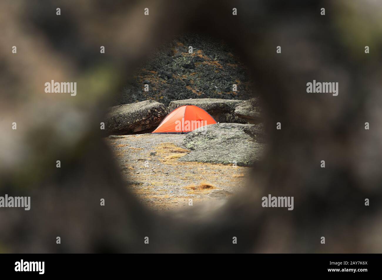 Tracking tent through a round hole in the stone Stock Photo - Alamy