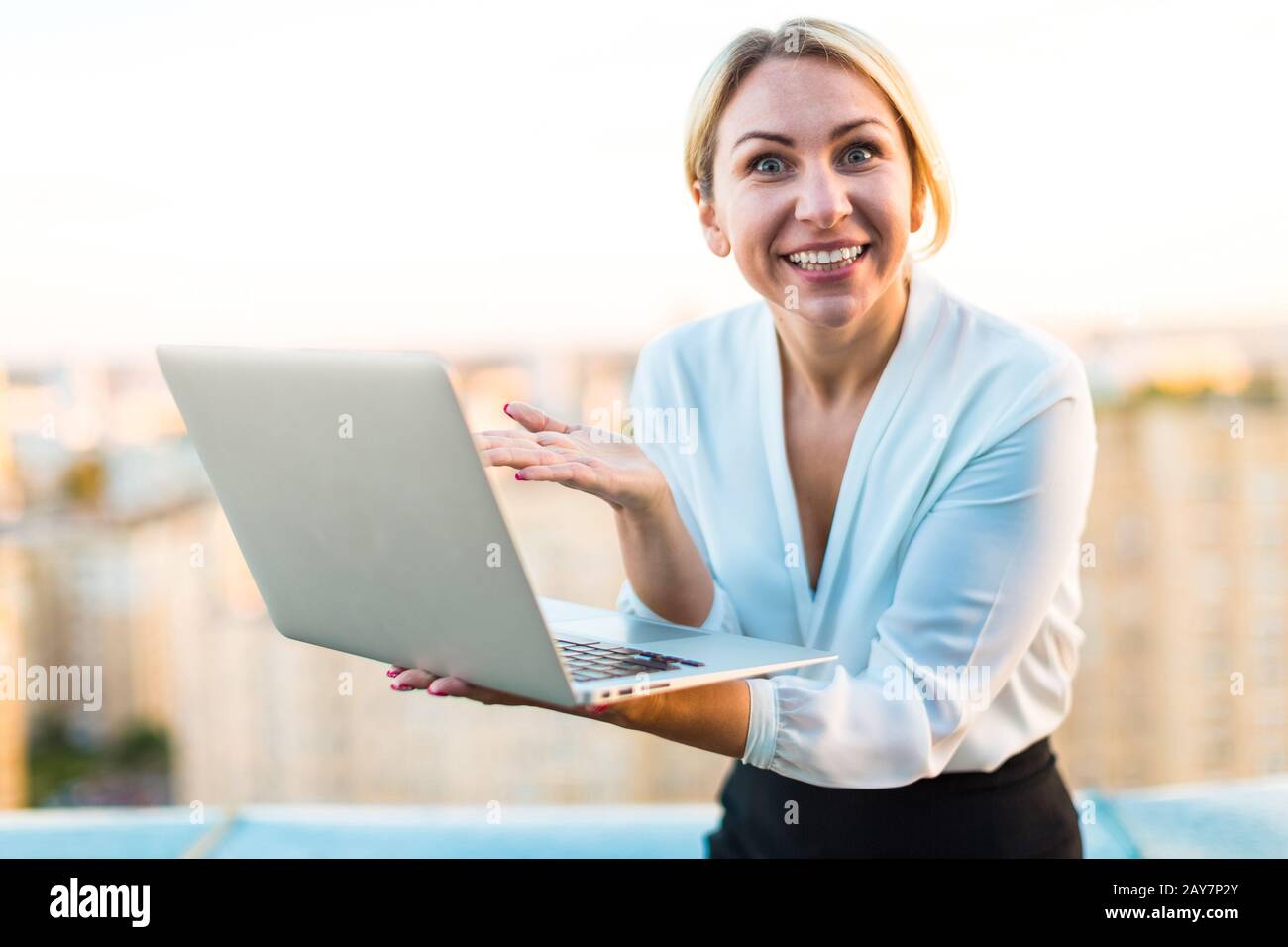 Beautiful smart business lady stand on the roof with laptop in h Stock ...
