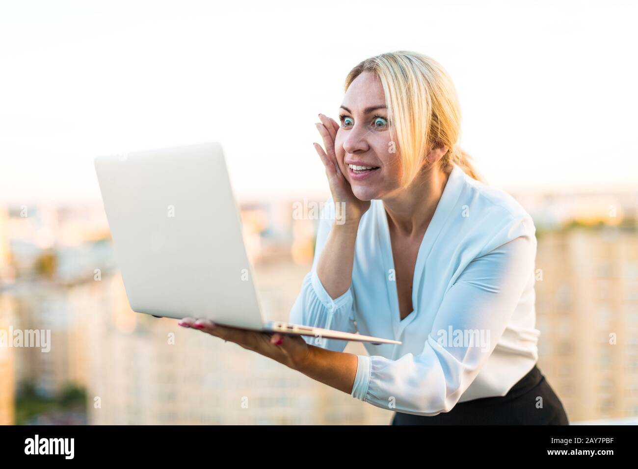 Beautiful smart business lady stand on the roof with laptop in h Stock ...