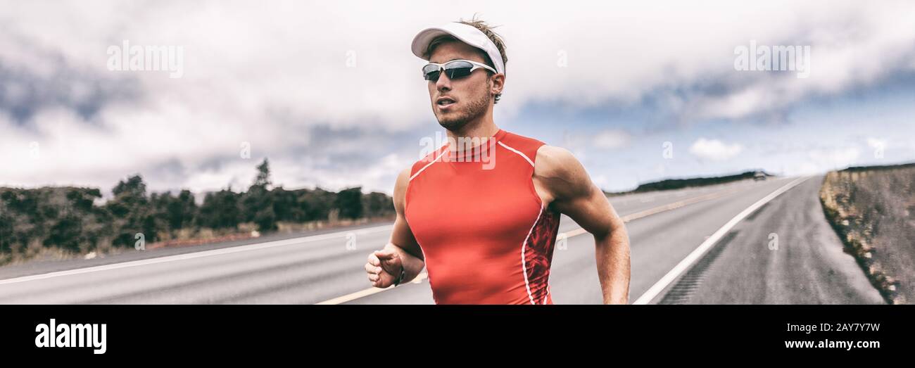 Triathlon runner man running on road panoramic backbround. Fit athlete ...