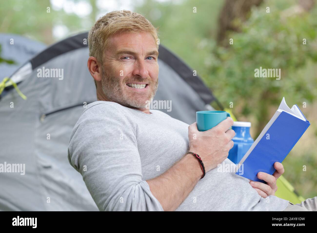 happy middle age man reading a book outdoors Stock Photo - Alamy