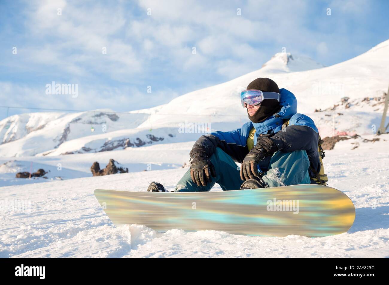 Smiling man snowboarder resting sit Stock Photo - Alamy