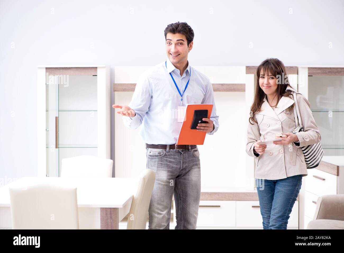 Salesman explaining to woman customer at furniture store Stock Photo ...