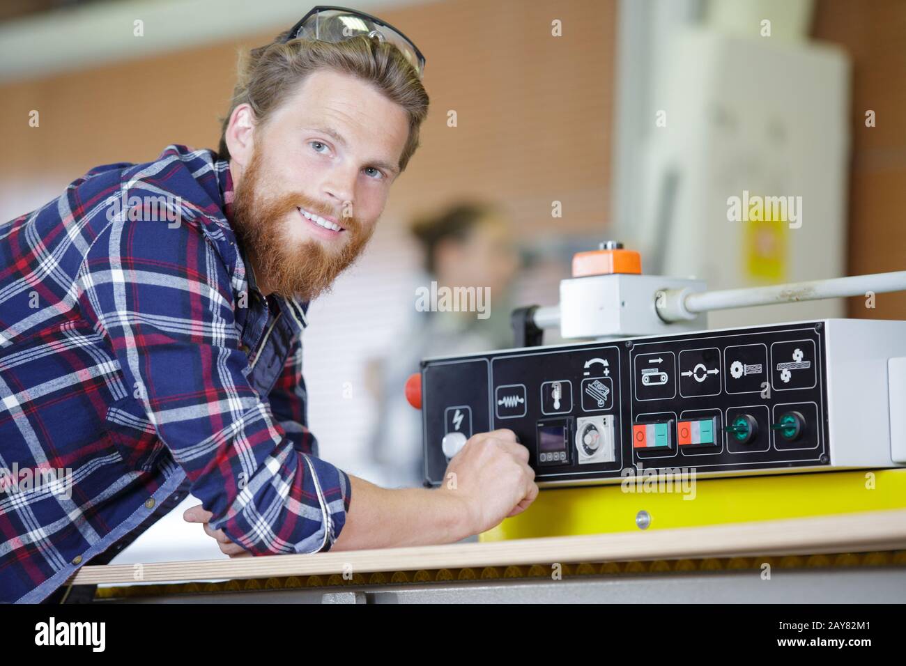 happy young man operating a machine Stock Photo - Alamy