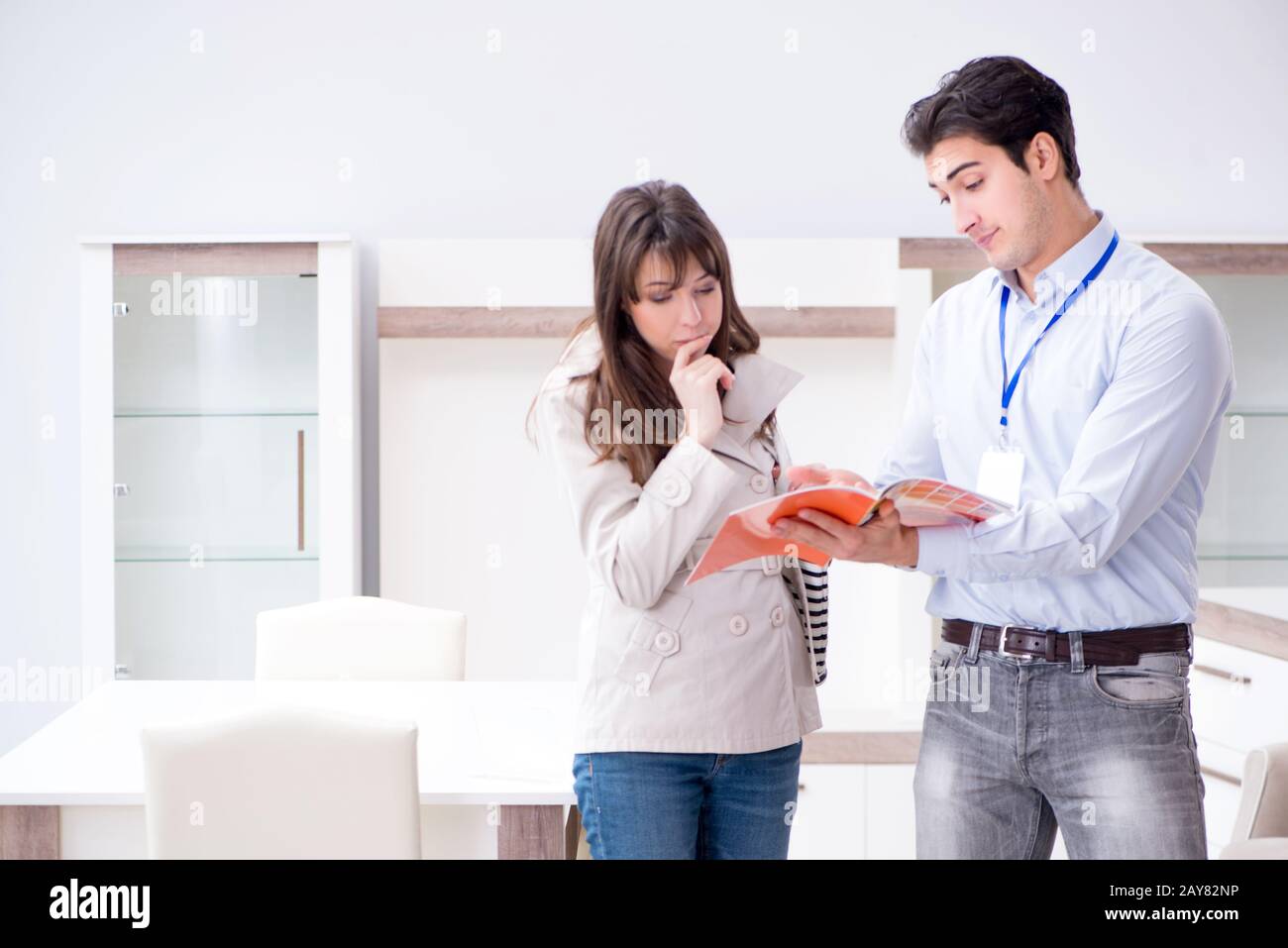 Salesman explaining to woman customer at furniture store Stock Photo ...