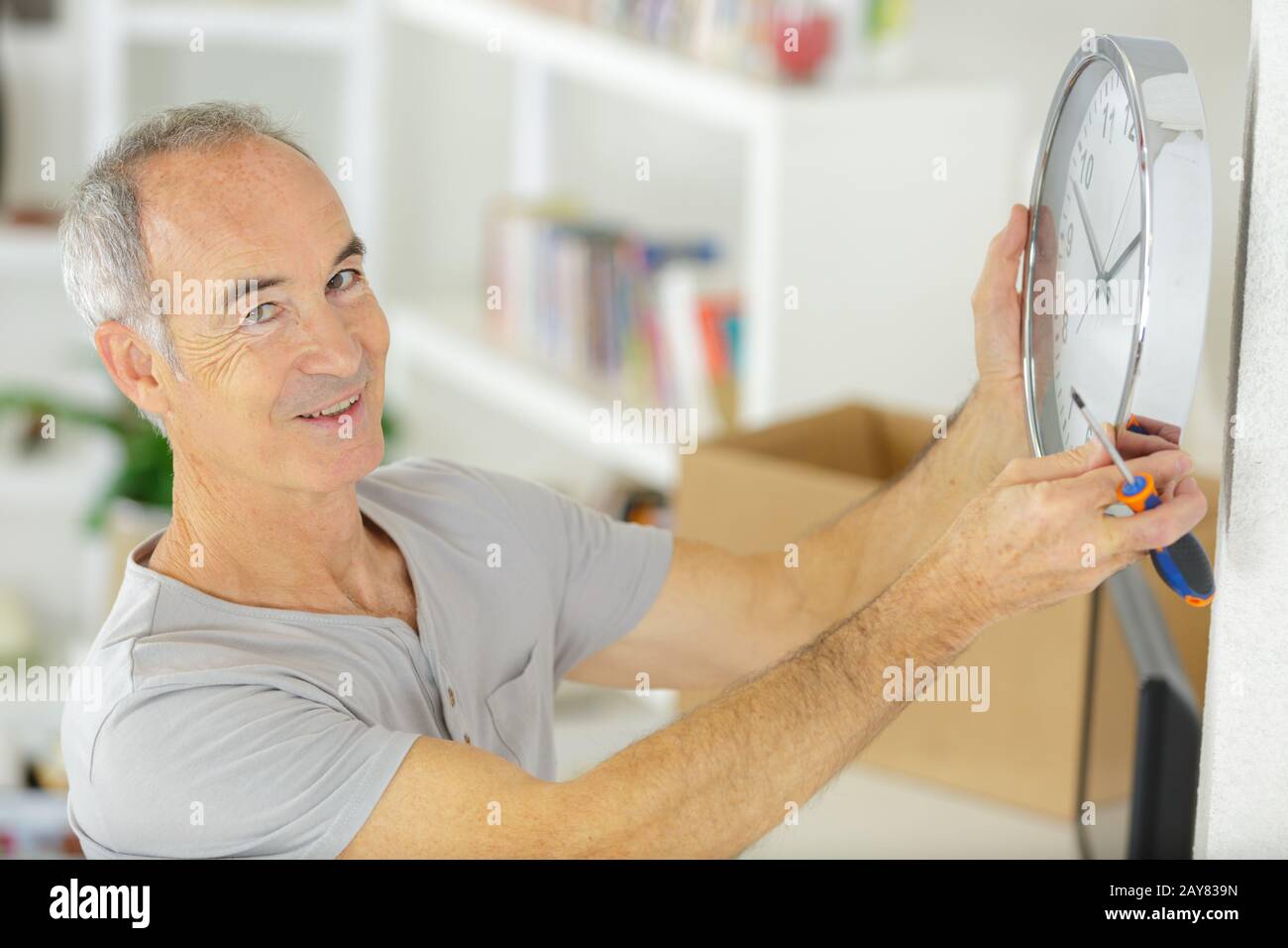Man hanging on clock hi-res stock photography and images - Alamy