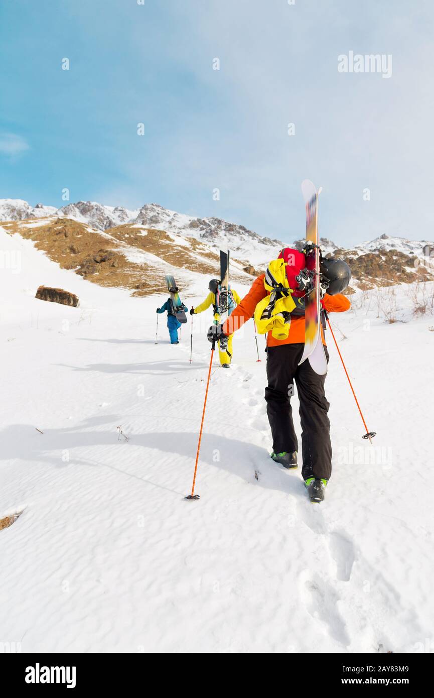 A group of three freeriders climb the mountain for backcountry skiing ...