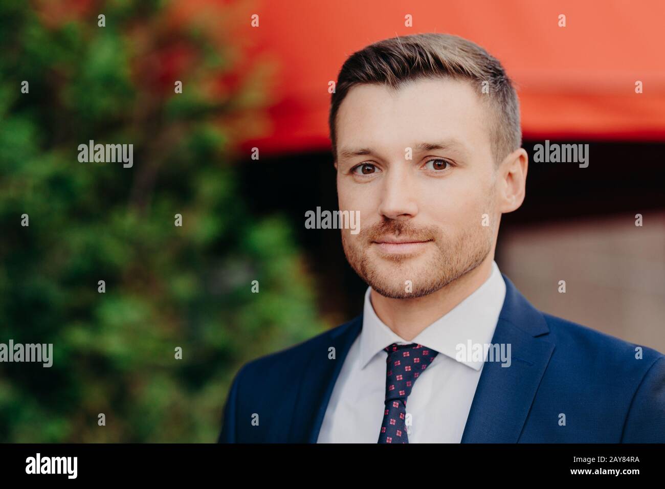 Headshot of attracttive successful male manager has confident serious ...