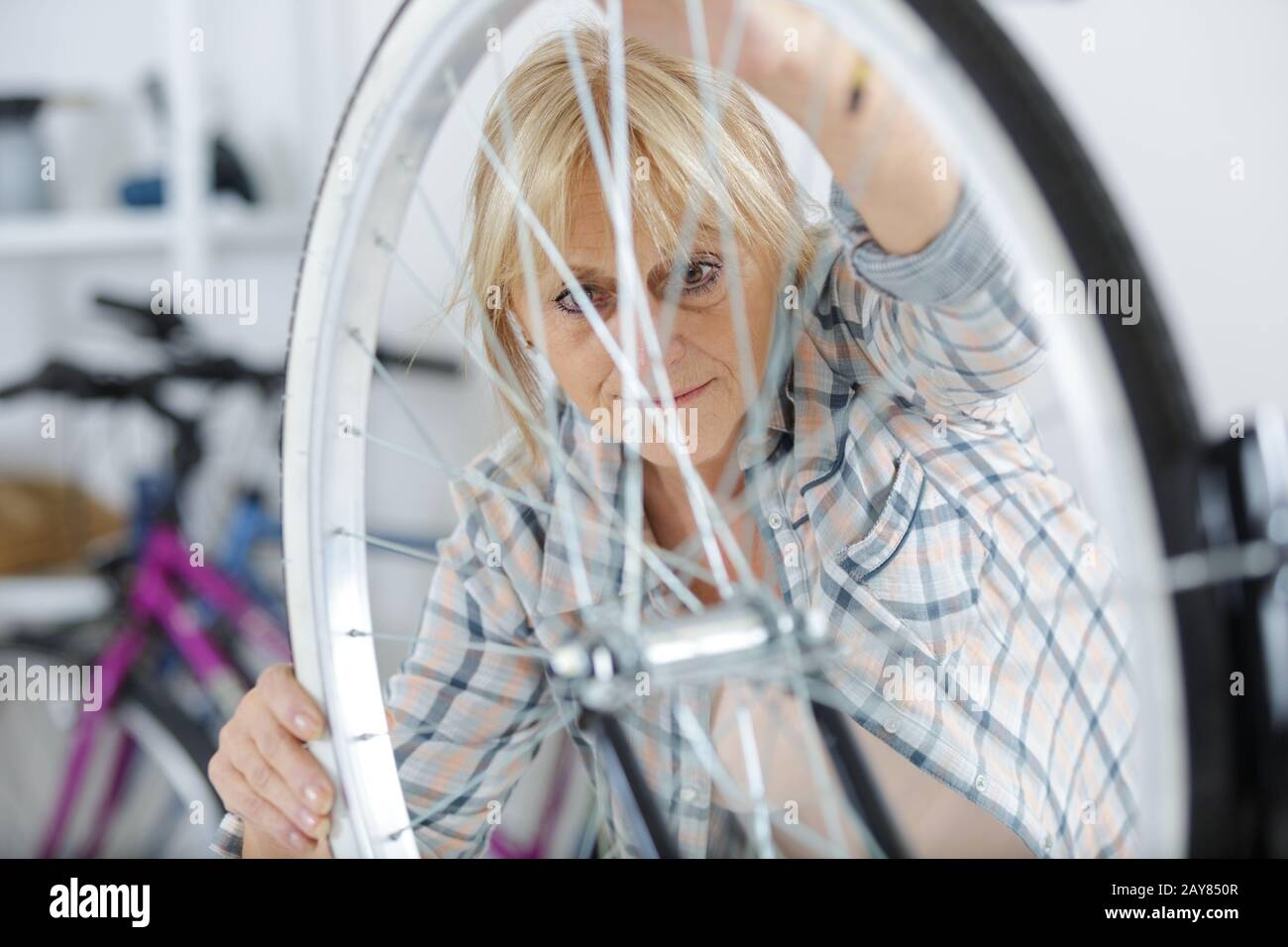 a mature woman fixing bike Stock Photo - Alamy