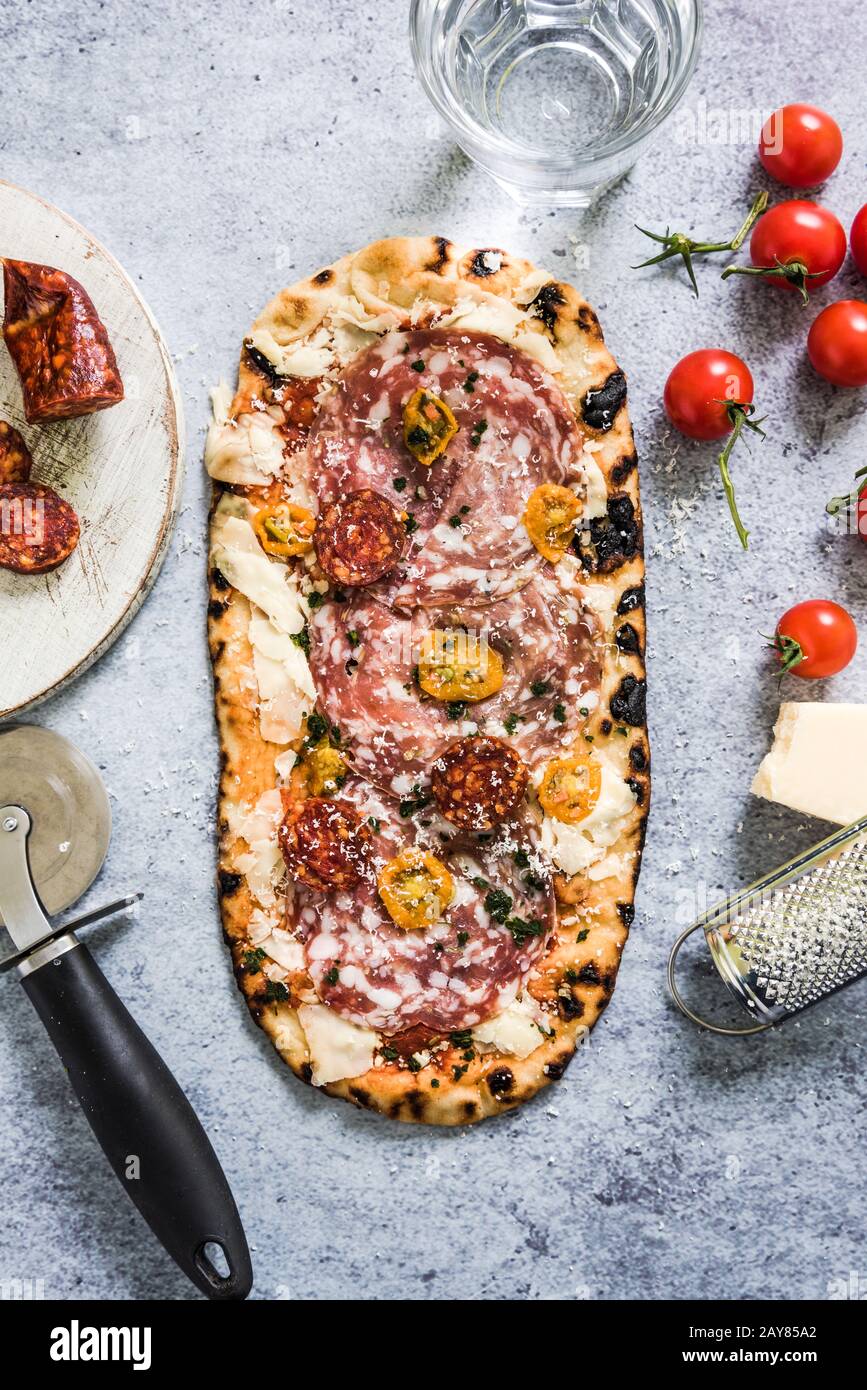 Italian salami and tomatoes pizza Stock Photo - Alamy