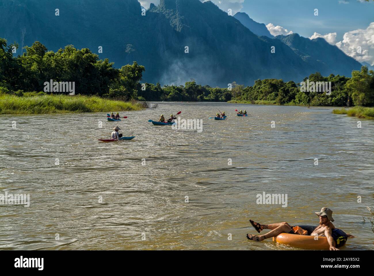 Tourists kayaking and tubing on the Nam Song river at Vang Vieng, Laos ...