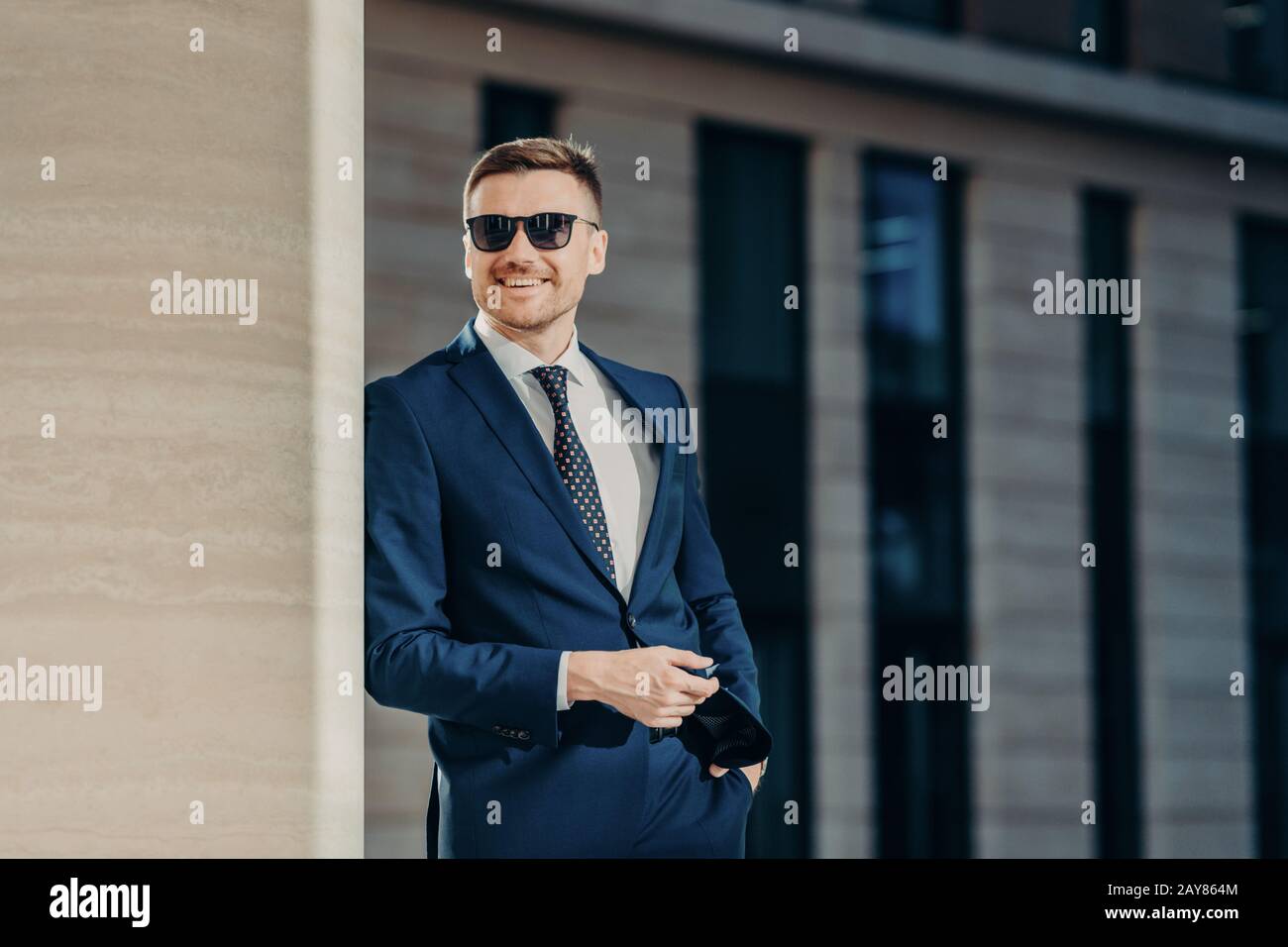 Confident unshaven male manager wears white shirt, black suit and tie ...