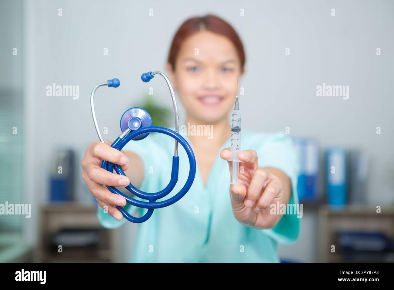 female nurse holding forward a stethoscope and syringe Stock Photo - Alamy