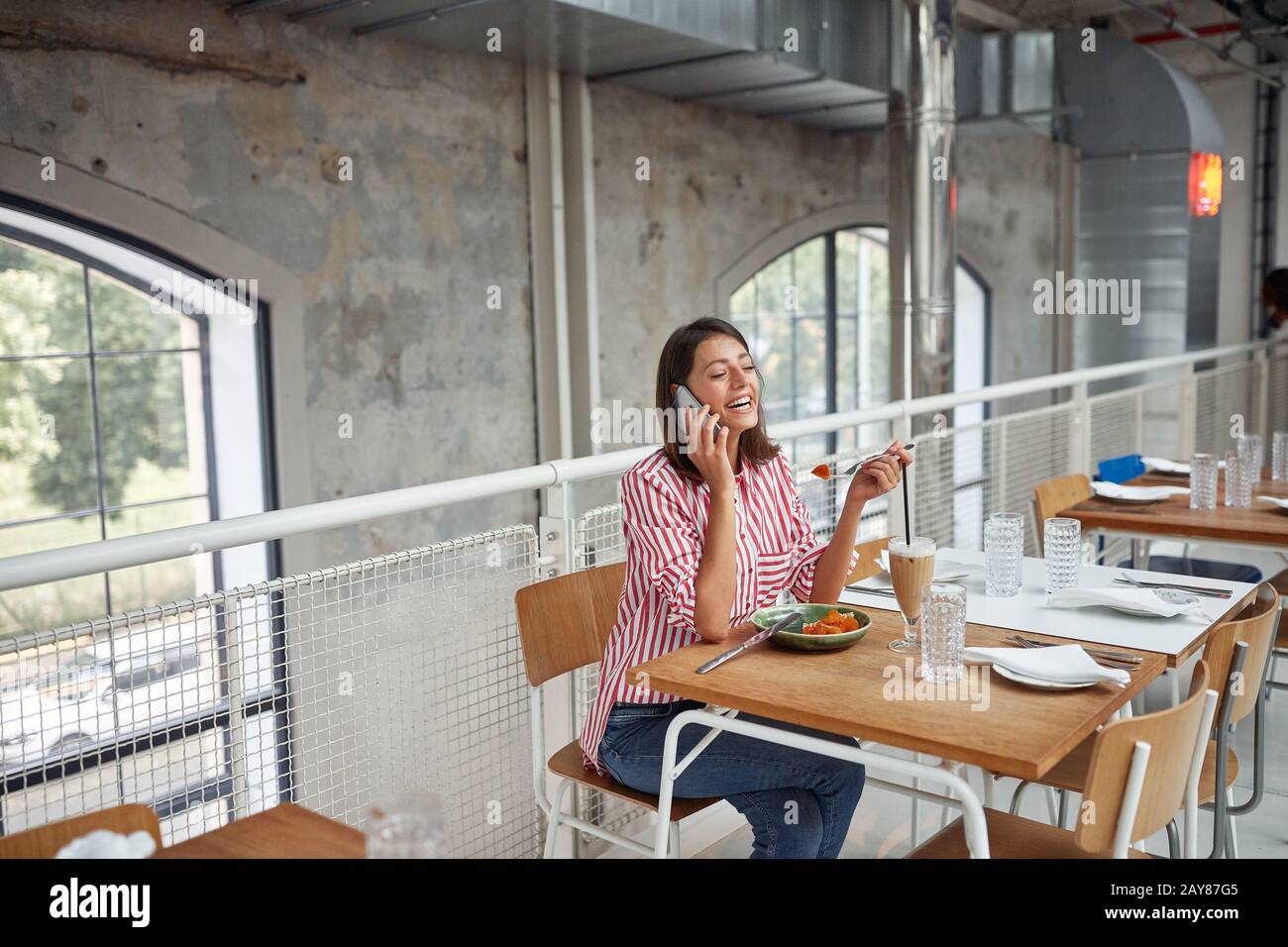 beautiful young woman talking on a cell phone in restaurant while ...