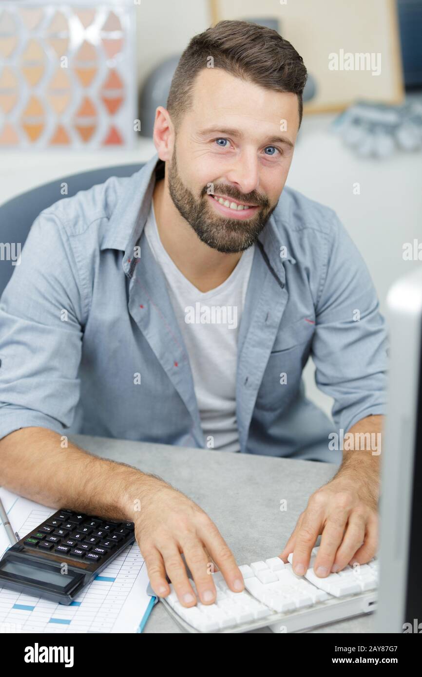 happy man calculates working on desk at office Stock Photo - Alamy