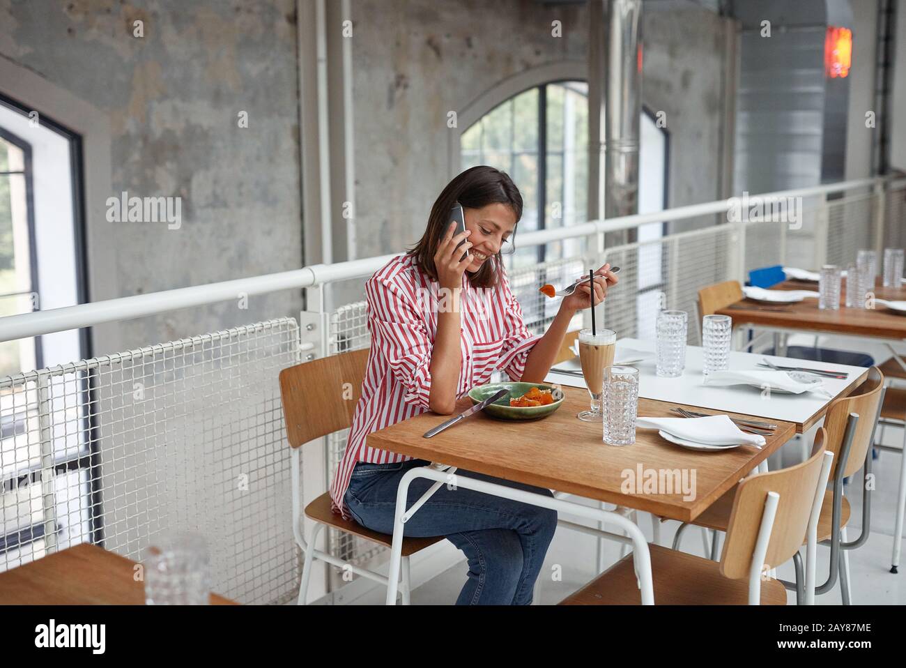 beautiful young female talking on a cell phone in restaurant while ...