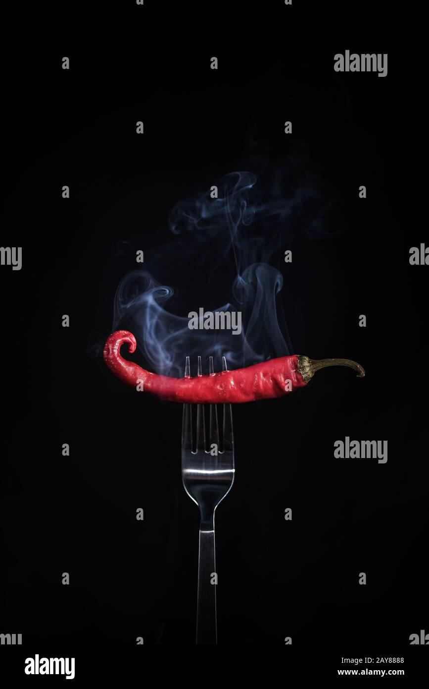 Smoking red hot chili on fork Stock Photo - Alamy