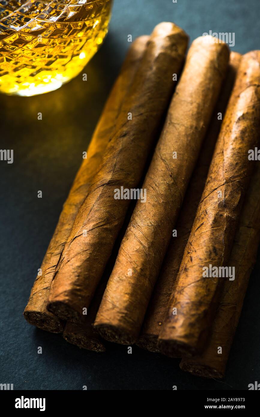 Cigars with alcohol on dark background Stock Photo - Alamy