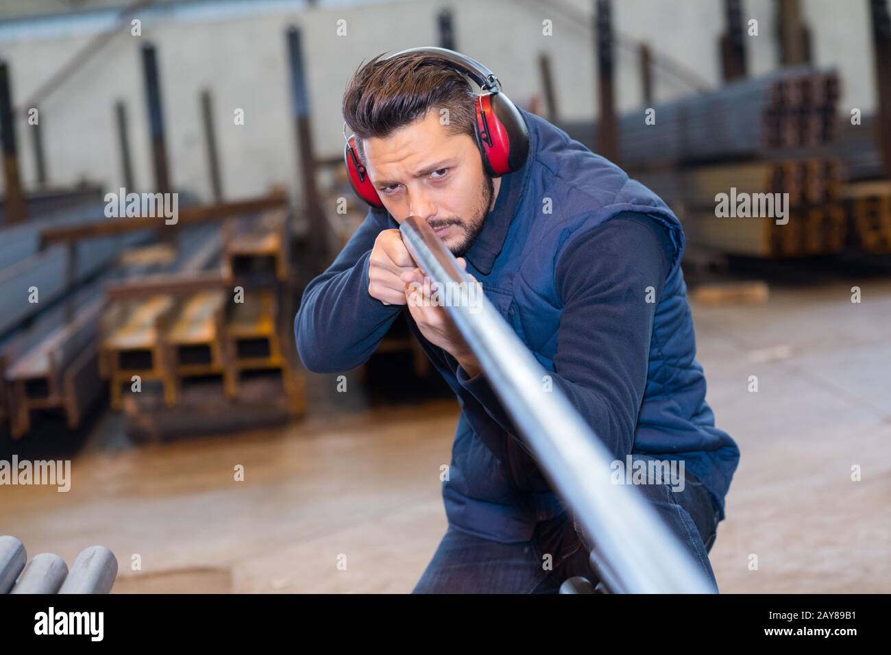 worker looking down the length of a metal pole Stock Photo - Alamy