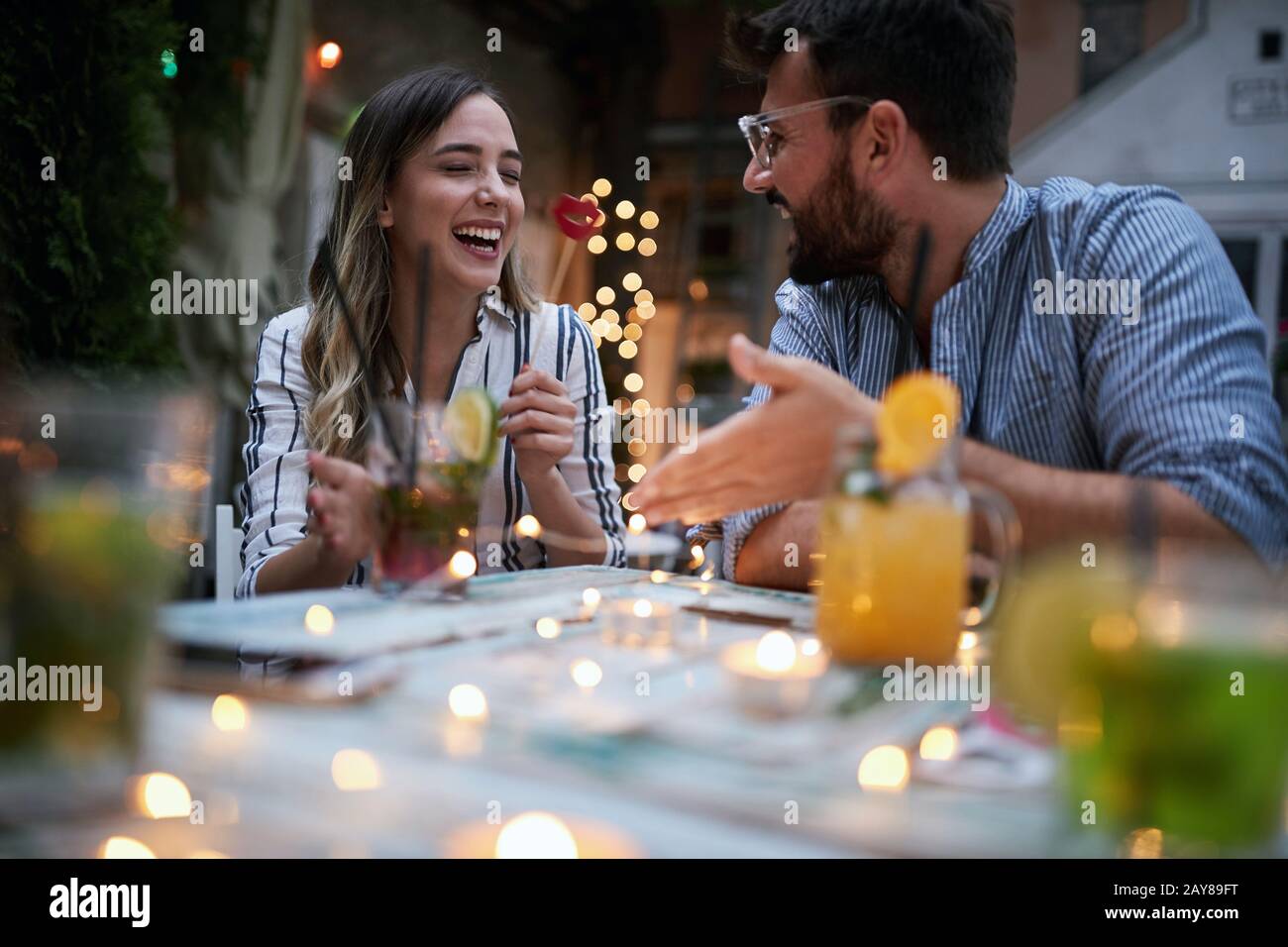young adult couple talking at cafe, having a drink. socializing ...