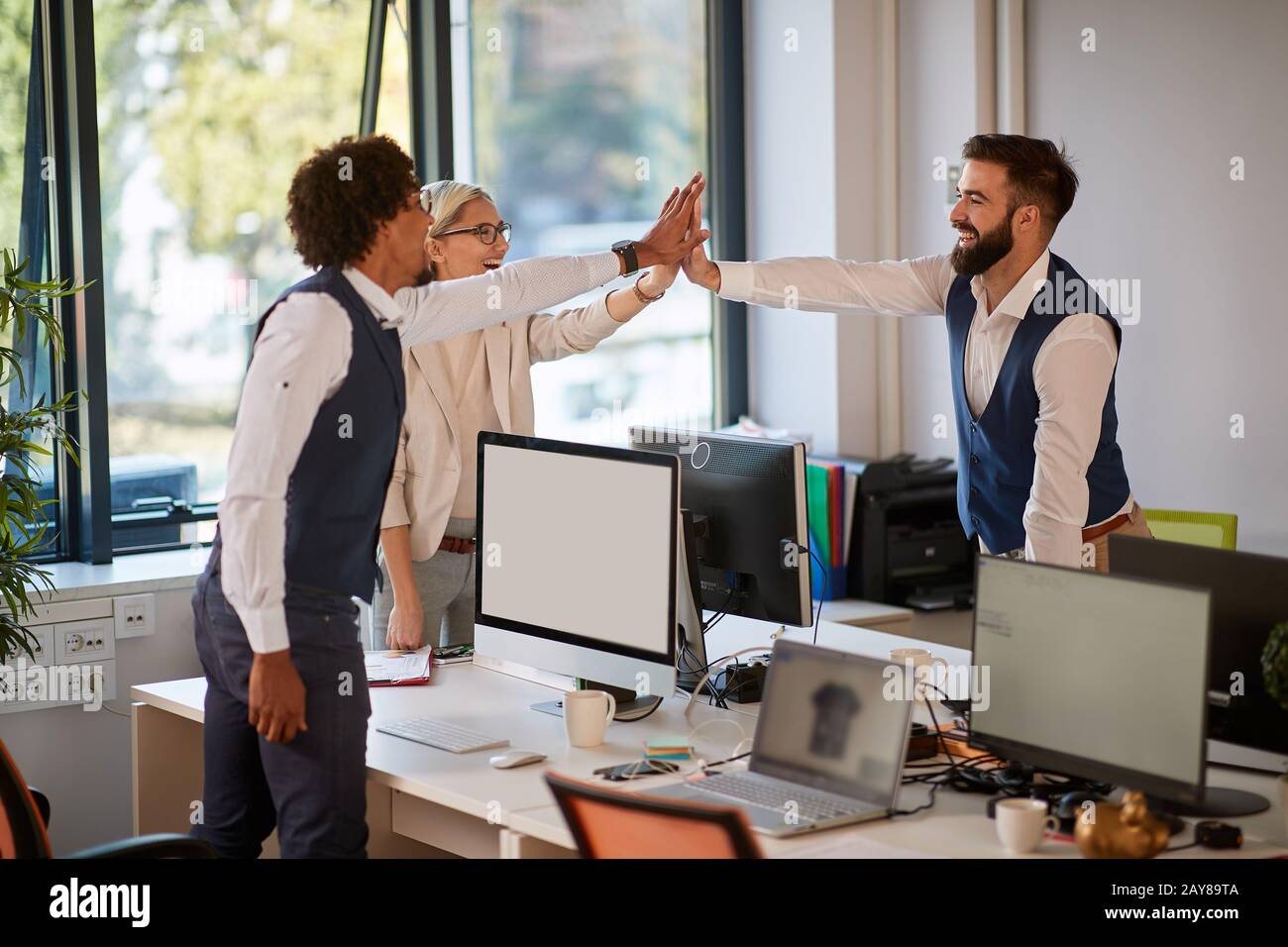 teambuilding moment of three colleagues in open space office. teamwork ...