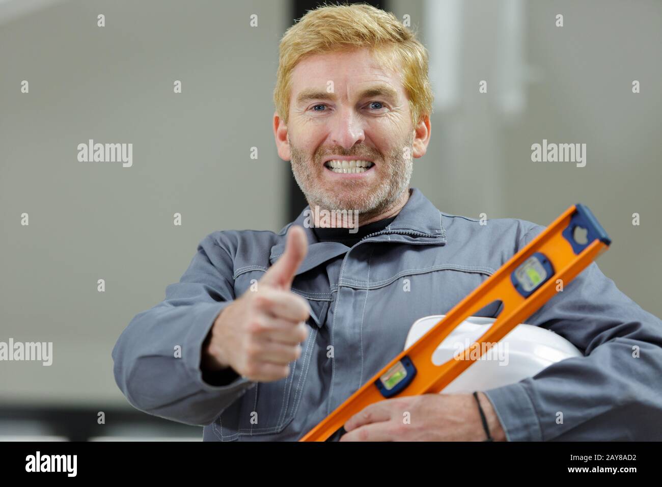 Smiling bricklayer holding level tool hi-res stock photography and ...