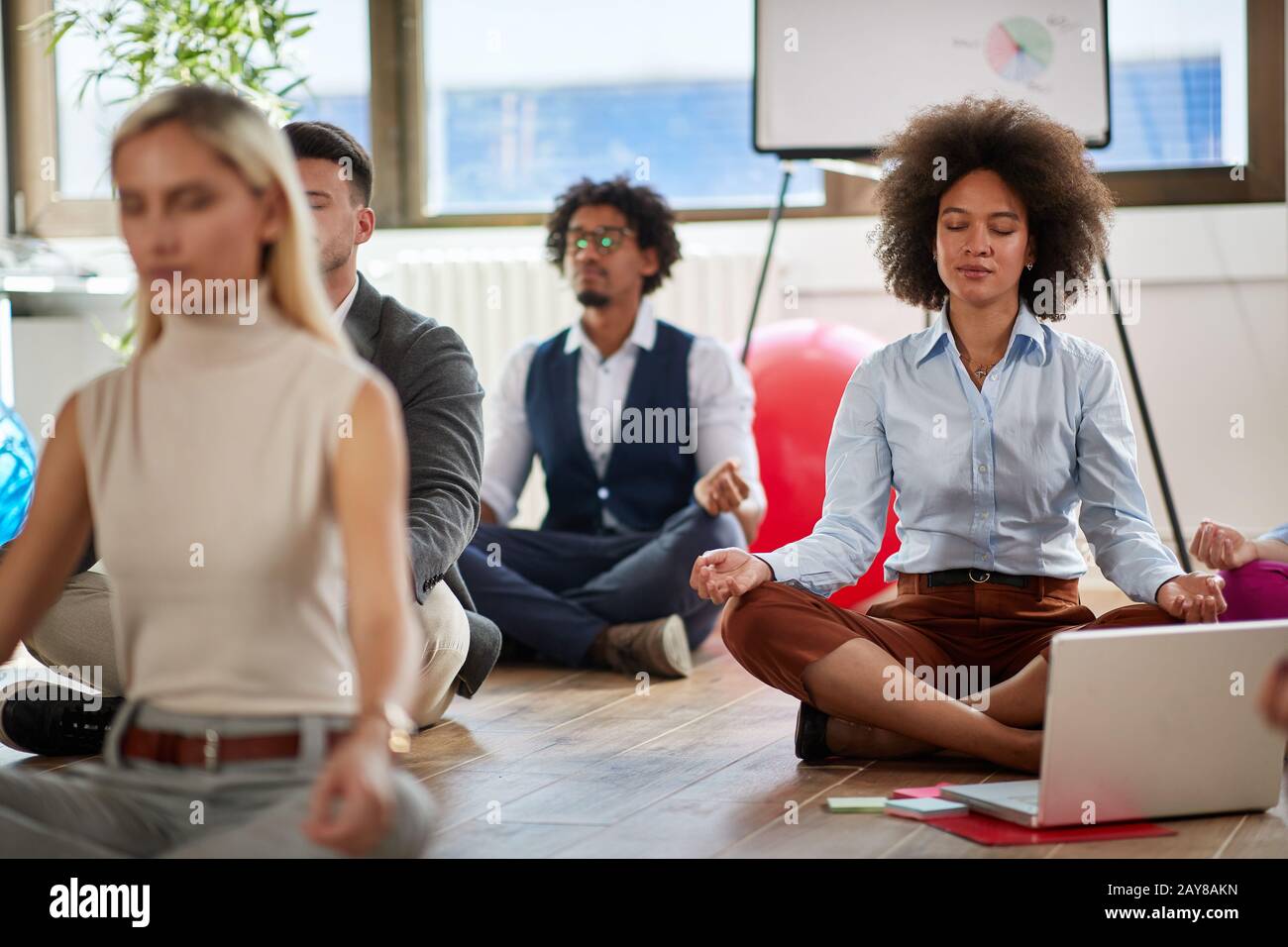 group of business coworkers meditating at work. modern, business ...