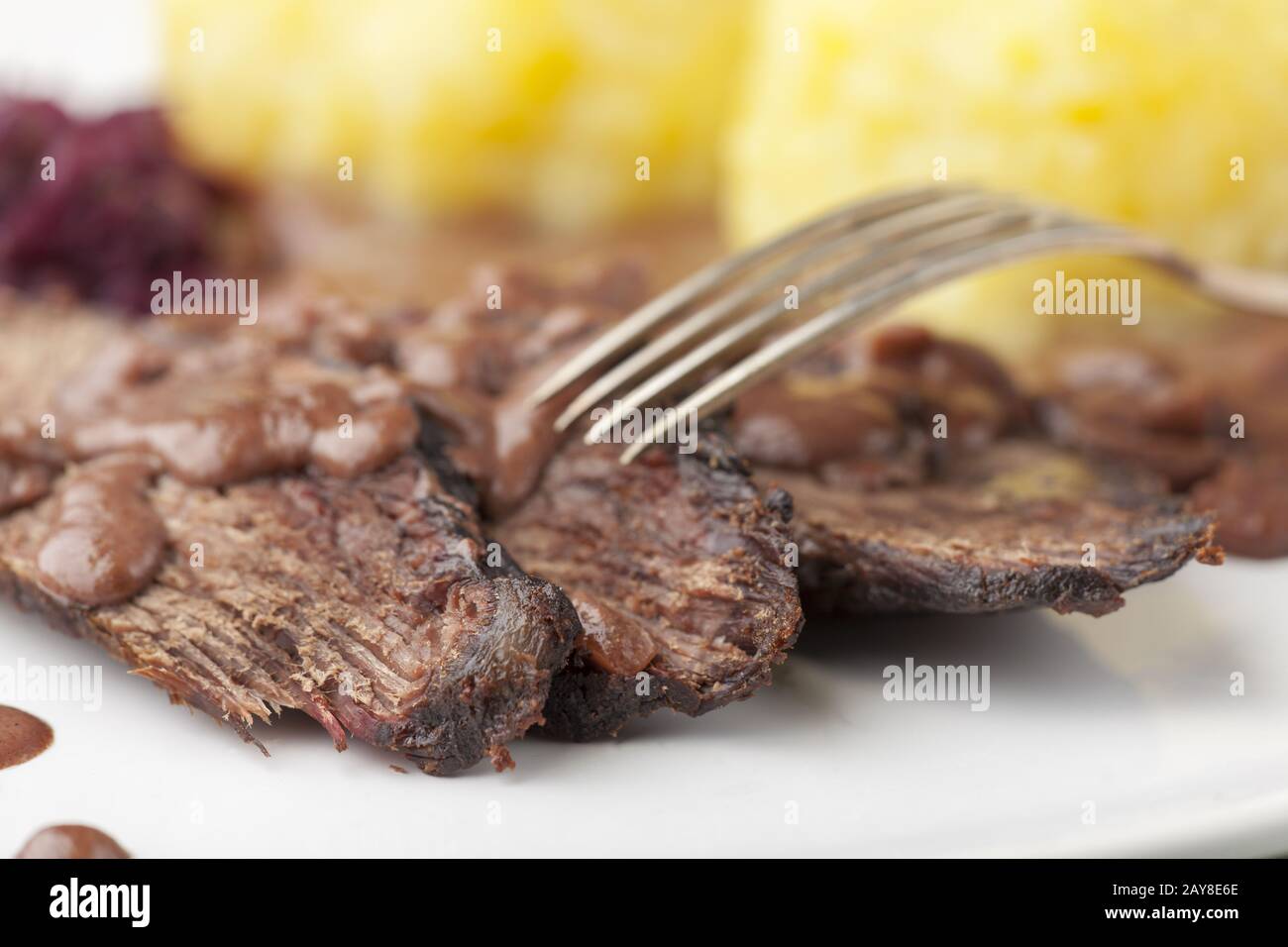 German Sauerbraten with red cabbage on a plate Stock Photo - Alamy