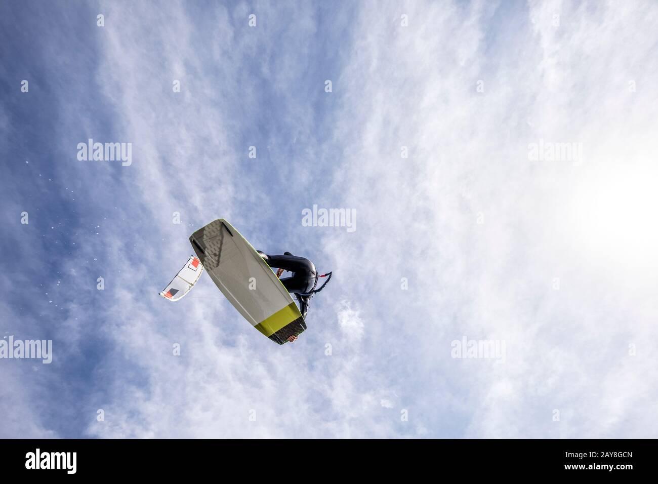 Kitesurfing or kiteboarding women jumping high overhead with a boards ...