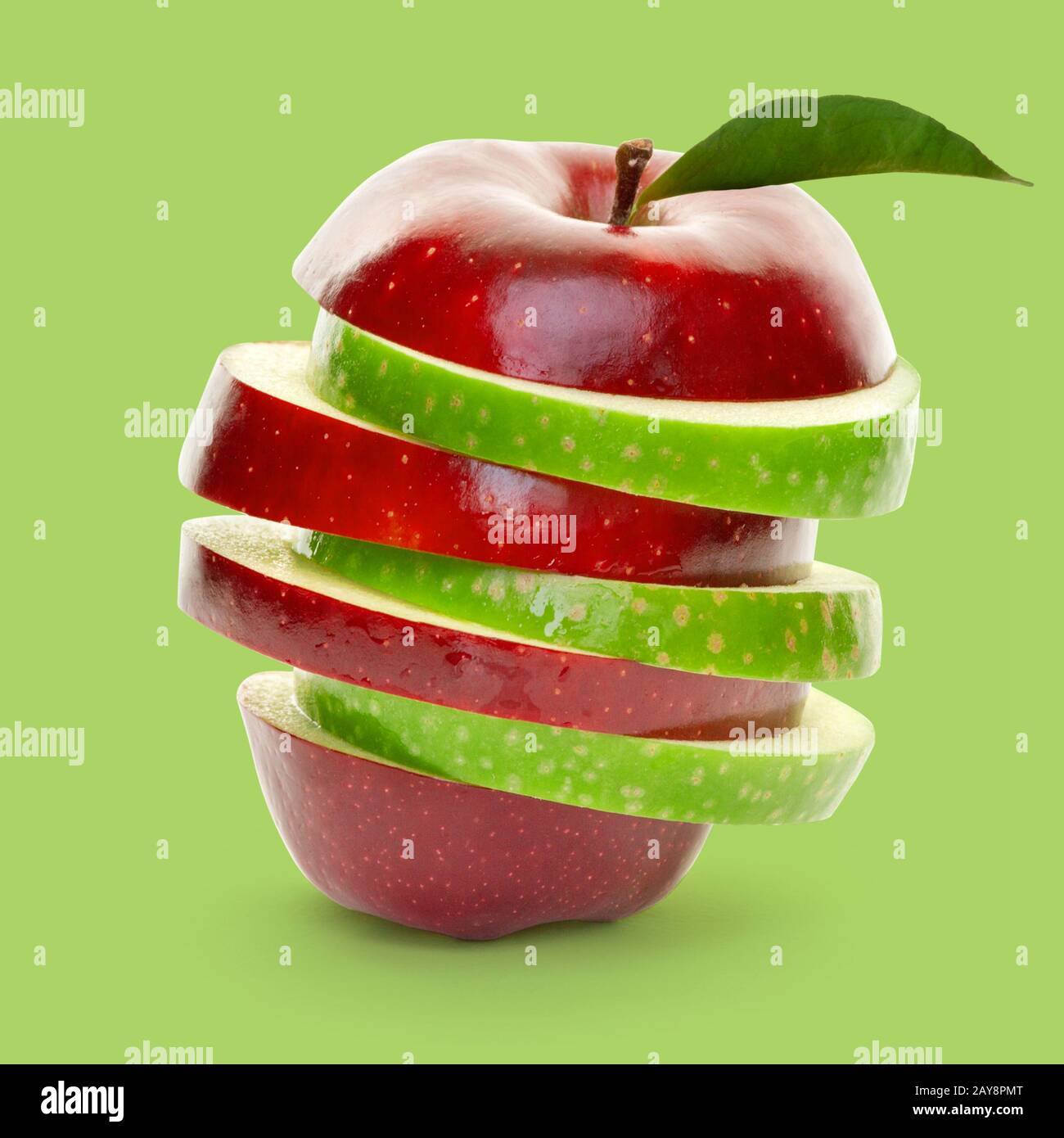 Mixed green and red apple slices piled up and isolated on green ...