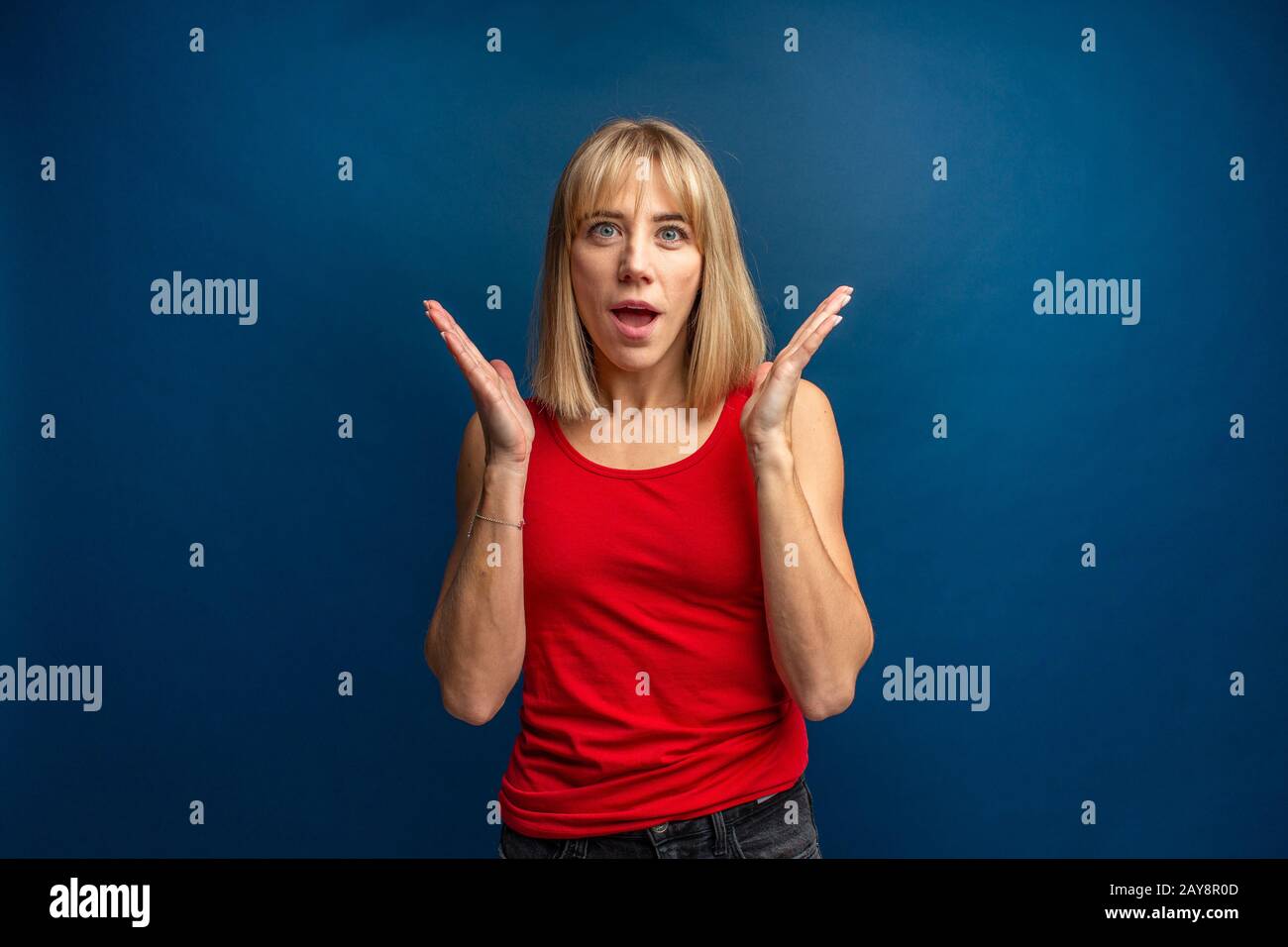 Surprised amazed beautiful blonde woman with wide open mouth looking at ...