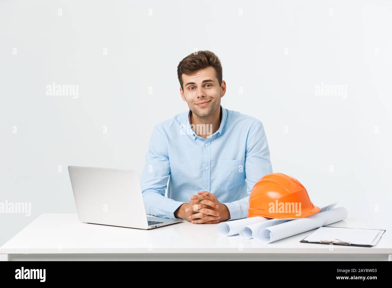 Handsome male construction engineer working in the office with laptop ...