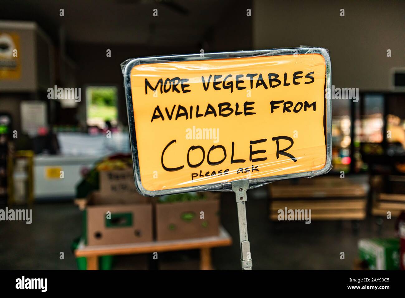 Hand written signs at the market reading more vegetables available from ...