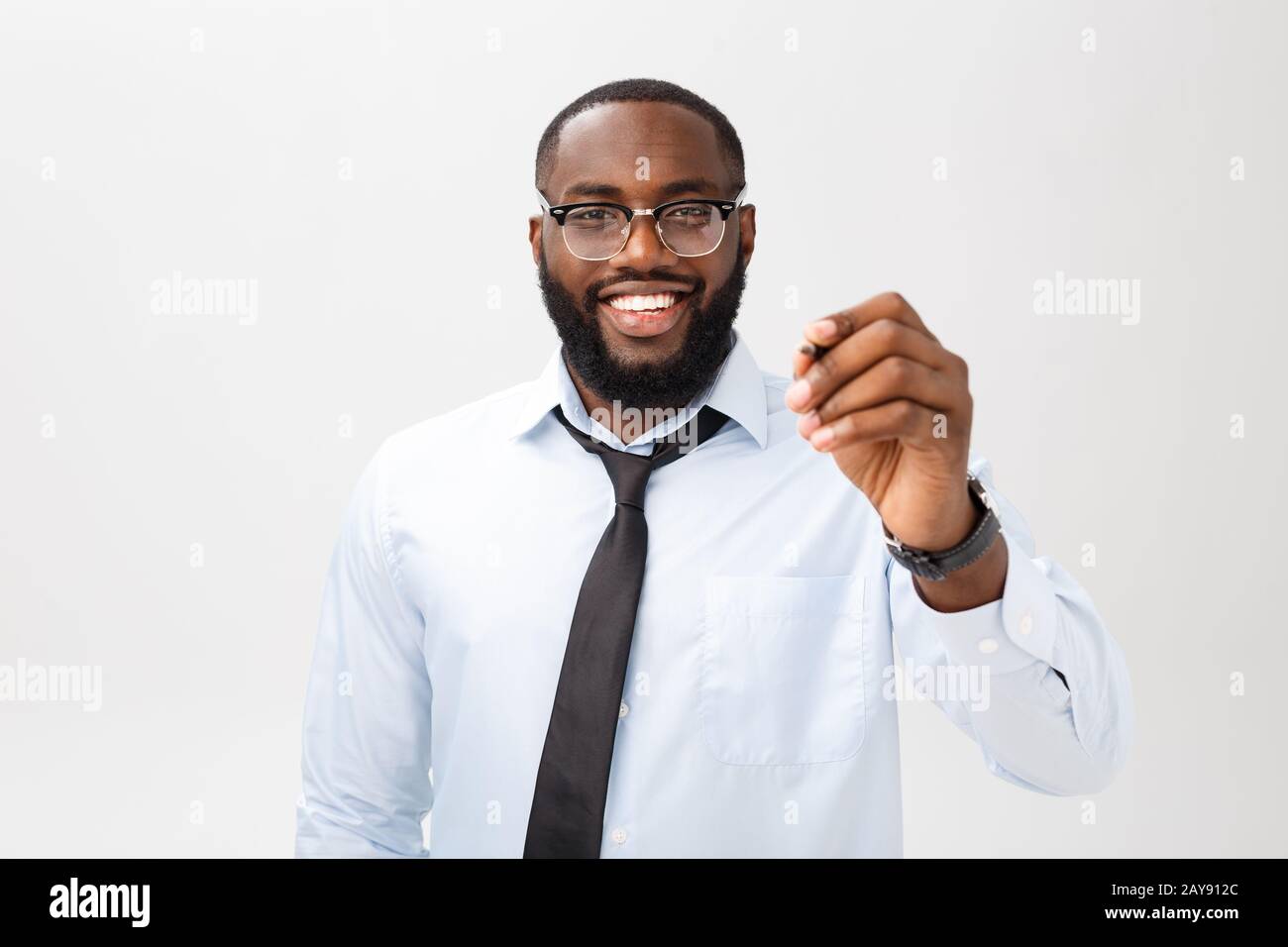 Young African american business man writing something on glass board ...