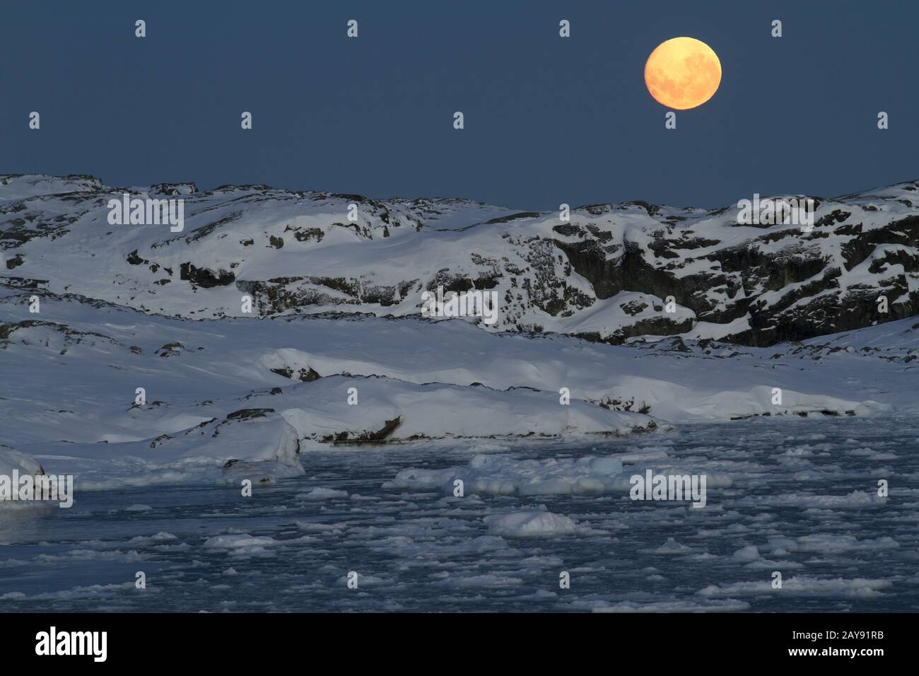 large bright moon over the Antarctic islands covered with snow on a ...