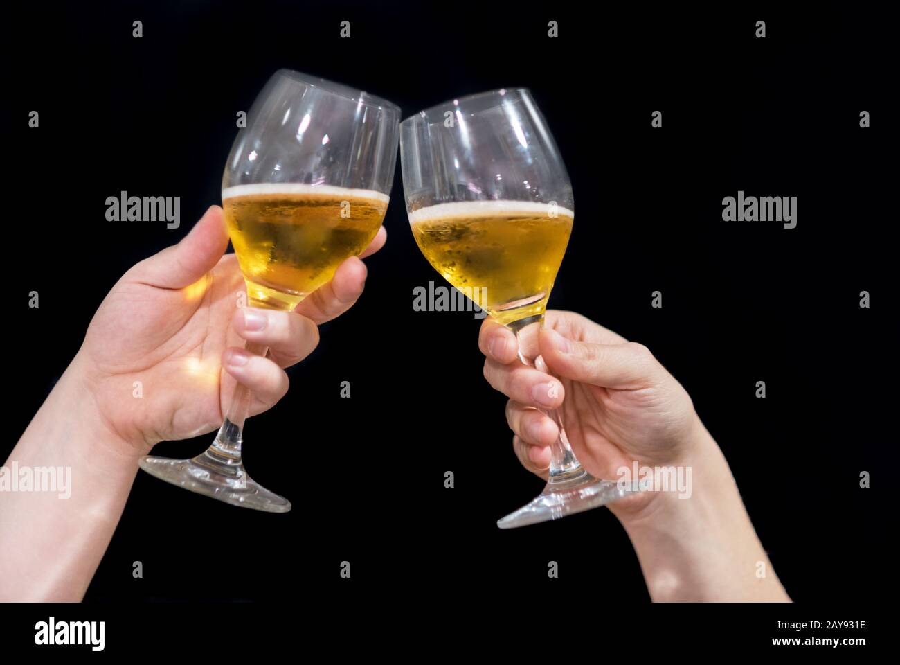 Two friends toasting with glasses of beer at the pub. Black isolated ...