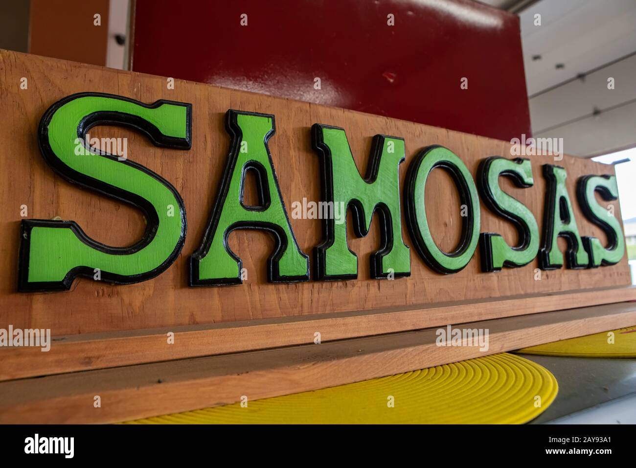 Big wooden sign with three-dimensional letter painted green. Sign reads ...