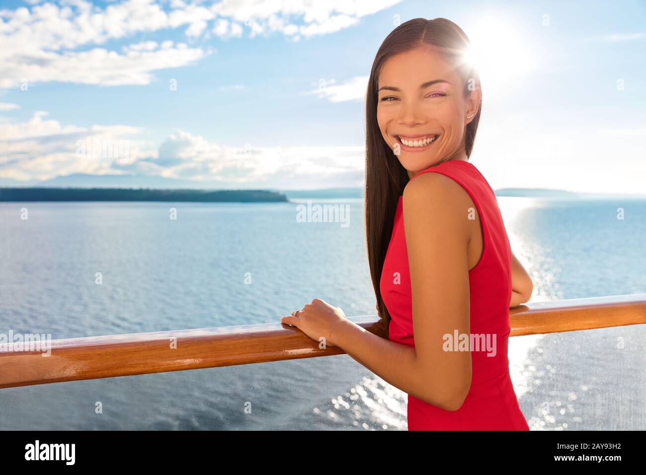 Happy cruise ship passenger outside on suite balcony enjoying luxury ...