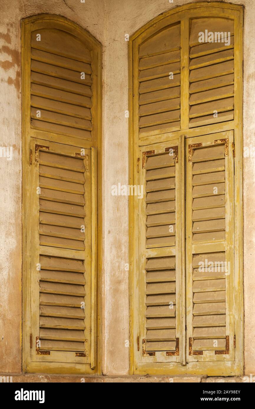 Wooden weathered vintage grunge yellow window shutters of old house ...