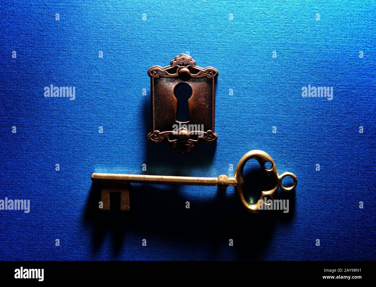 Lock and key on blue Stock Photo - Alamy