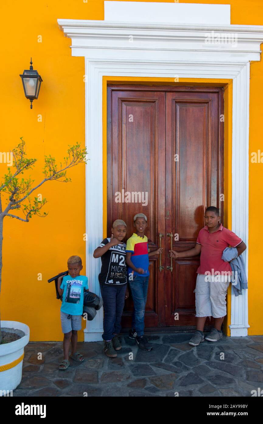 Local boys in front of a door of a brightly colored house in the Bo ...