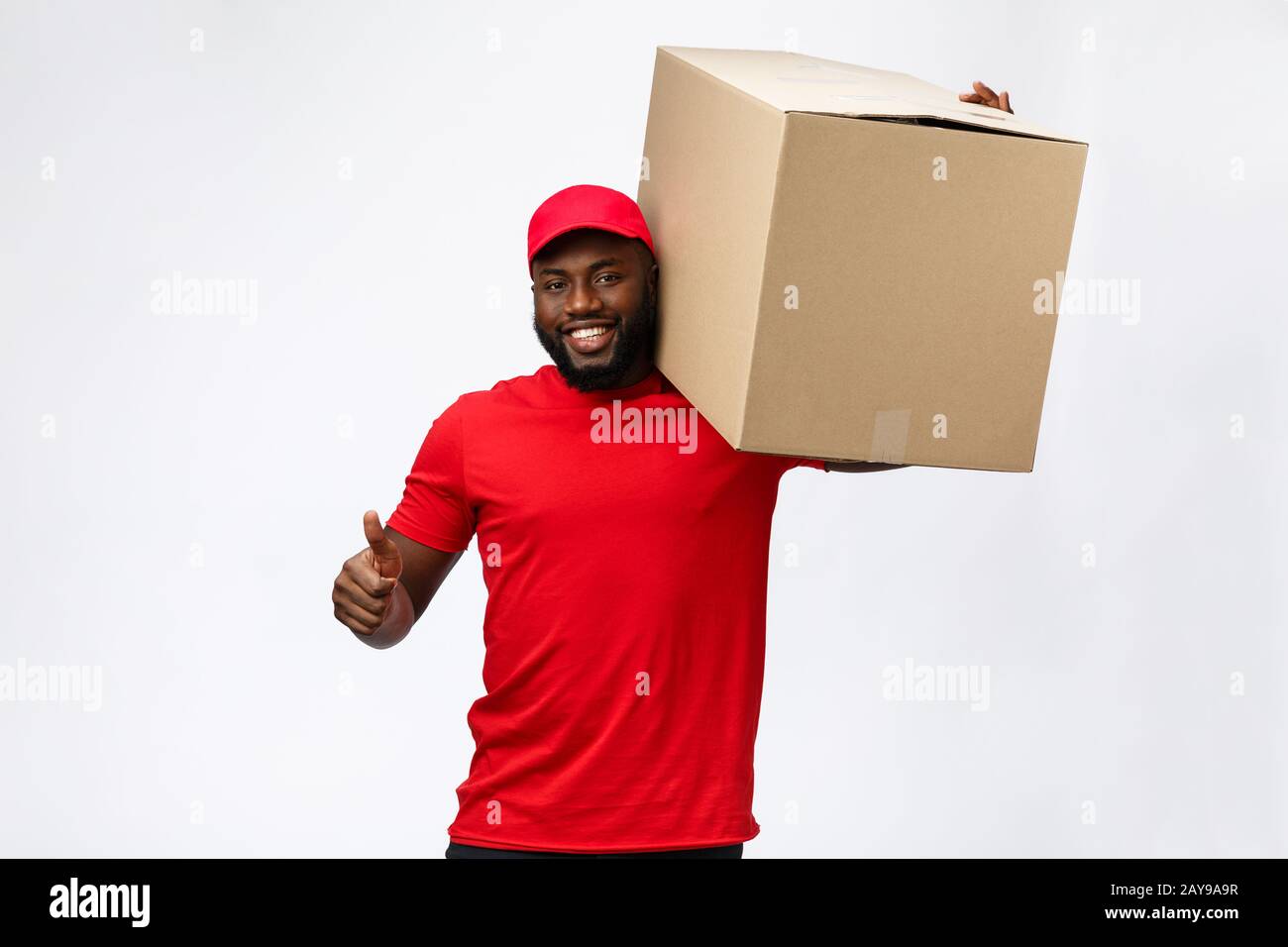 Delivery Concept - Handsome African American delivery man carrying ...
