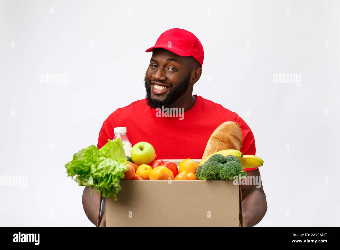 Delivery Concept - Handsome African American delivery man carrying ...